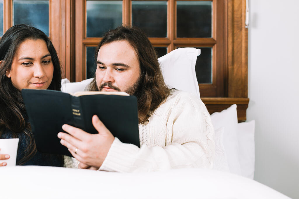 Husband And Wife Reading The Bible Together In Bed Graphics For The